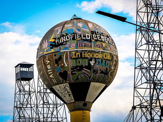 The water tower transformed into art canvas proclaims "In Honor Of Mom + Dad"—family inspiration reaching toward the heavens.