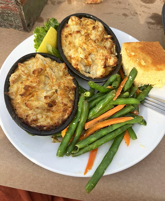 Crab imperial—where crab meat goes to achieve its highest purpose. Two ramekins of pure Maryland bliss alongside vegetables pretending to be the main event.