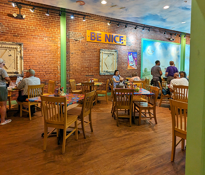 Exposed brick walls, wooden chairs, and a "BE NICE" sign—Southern hospitality isn't just served here, it's built into the architecture.