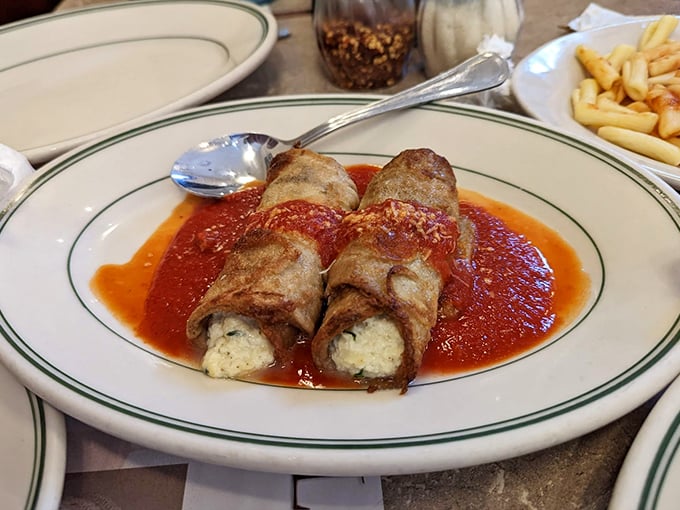 Eggplant ricottatini rolls lounging in marinara like they're at a luxurious spa bath – vegetarian food that makes carnivores question their life choices.