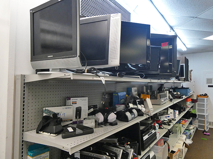 Technology's timeline displayed on metal shelves. From bulky CRTs to sleek monitors, the electronics section is a museum of digital evolution.