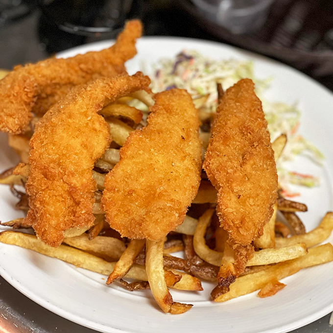 Golden-battered fish fillets perched atop hand-cut fries with coleslaw standing by. The British would approve, though they'd insist on calling it "chips."