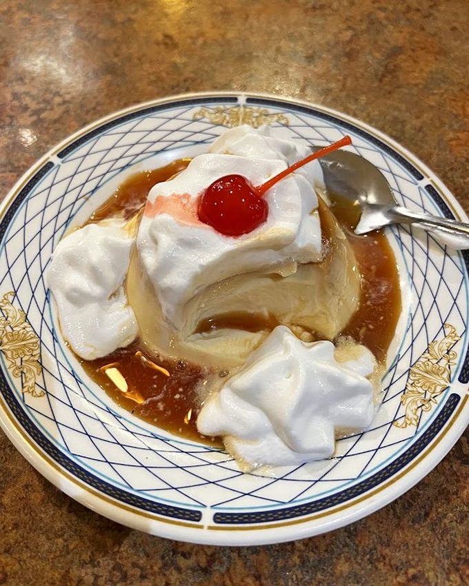 Flan wearing a whipped cream hat and cherry beret—the dessert equivalent of that friend who's both sophisticated and fun at every party.
