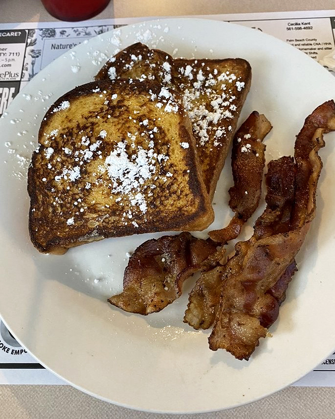 French toast dusted with powdered sugar and served with crispy bacon—breakfast's perfect sweet and savory romance on a plate.