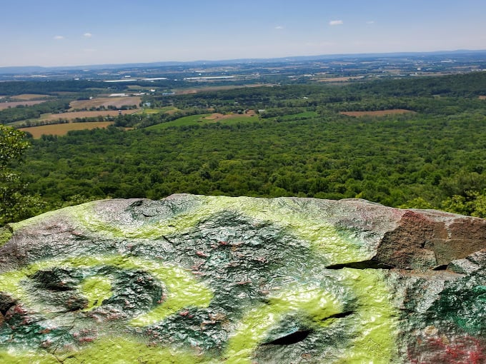 The rocks tell stories in spray paint – part vandalism, part community bulletin board, completely charming.