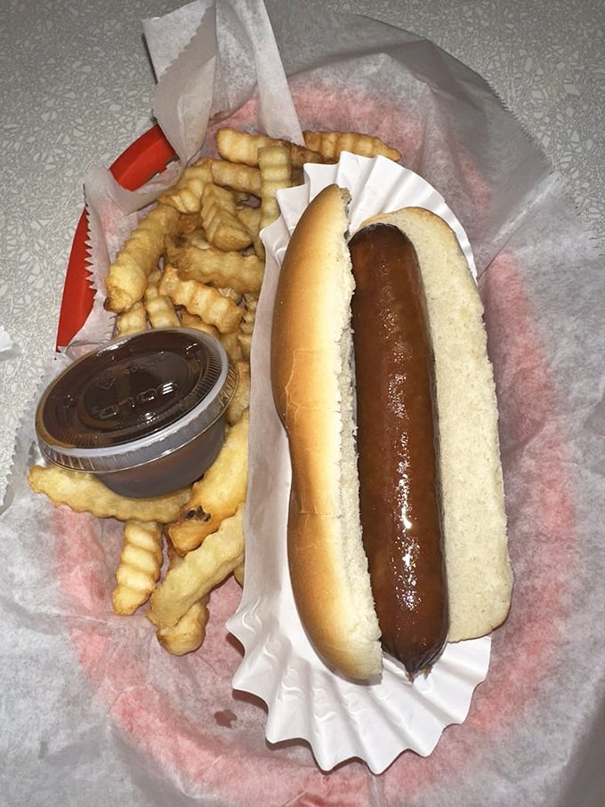 A hot dog that respects tradition—nestled in a soft bun with crinkle-cut fries that crunch like autumn leaves underfoot.