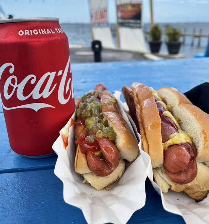 Two perfectly dressed hot dogs with a Coca-Cola – sometimes simple perfection needs no explanation whatsoever.