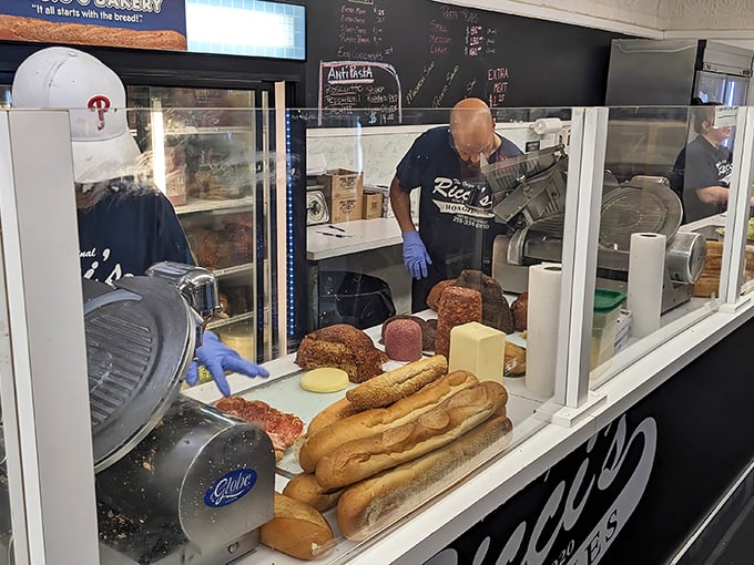 The sandwich assembly line reveals the building blocks of happiness – fresh rolls, quality meats, and the practiced hands of experience.