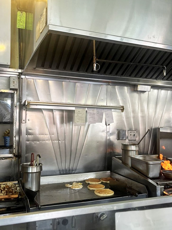 The kitchen ballet in full swing – pancakes flip while the griddle sizzles its morning symphony.