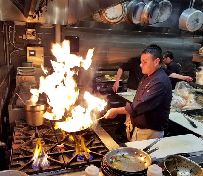 Flames leap dramatically in the open kitchen. This isn't just cooking—it's culinary theater where fresh seafood gets the star treatment it deserves.