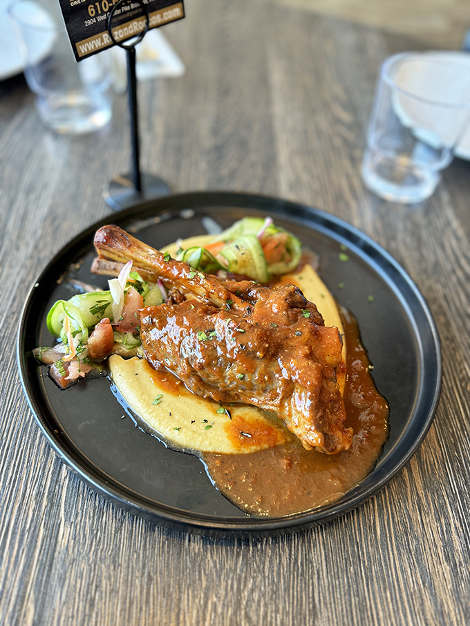 This lamb shank isn't just falling off the bone – it's practically filing for independence on a bed of creamy polenta.