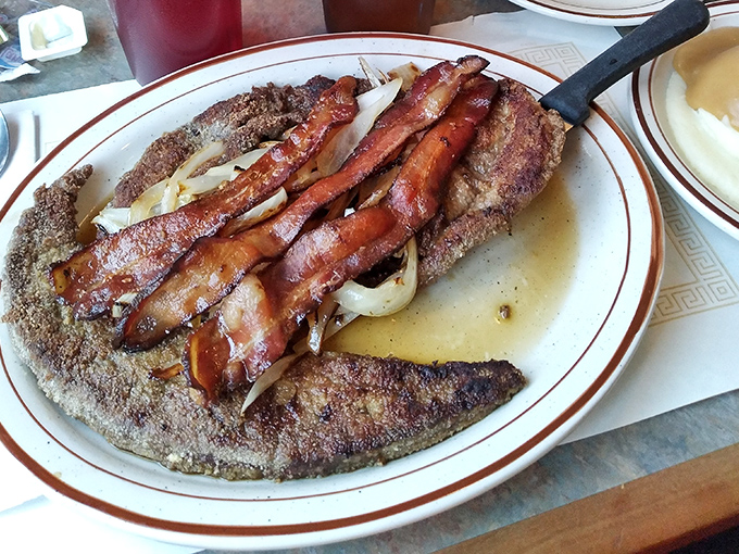 Liver and onions—the dish that separates the culinary adventurers from the tourists. Topped with bacon because Pennsylvania knows how to improve perfection.