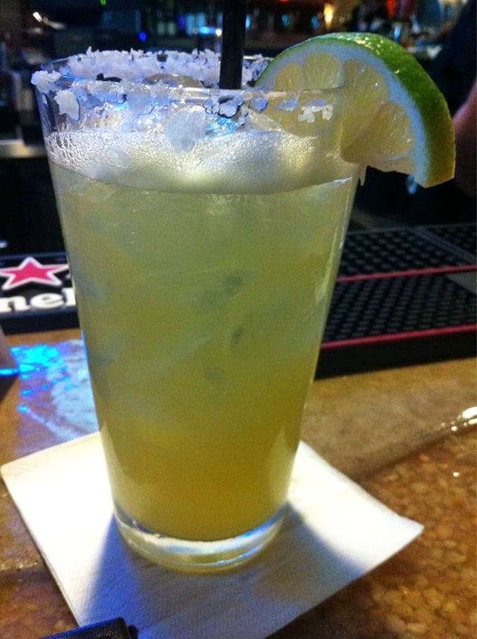 A proper margarita with salt-crusted rim and lime wedge—the kind that makes you contemplate canceling your afternoon plans in favor of ordering a second.