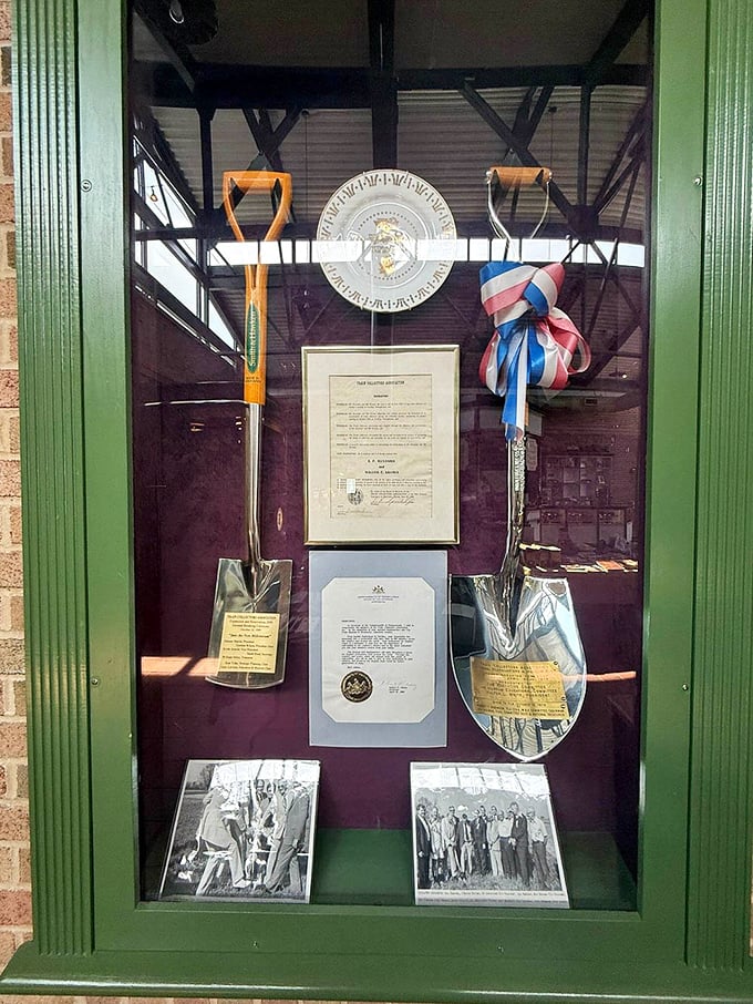 History preserved behind glass—ceremonial shovels and documents marking the museum's groundbreaking, a shrine to serious train play.