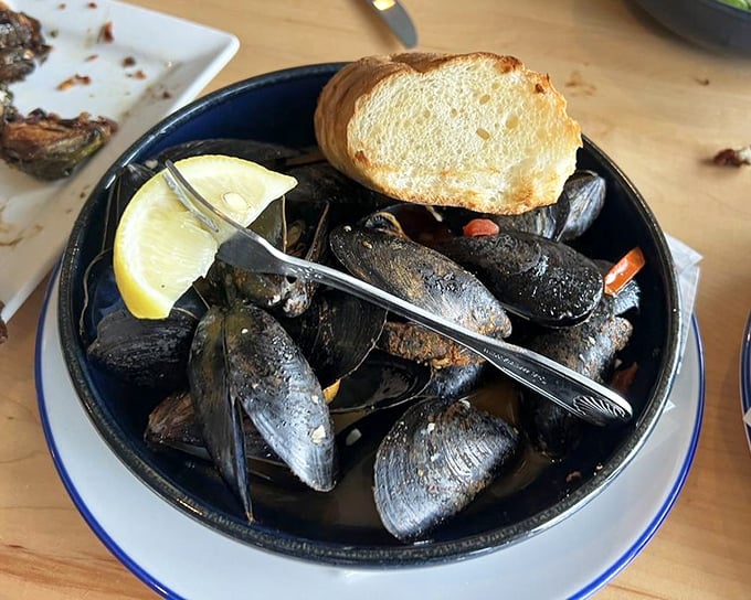 These mussels aren't just served—they're presented like the maritime treasures they are, complete with crusty bread for that essential sauce-sopping.
