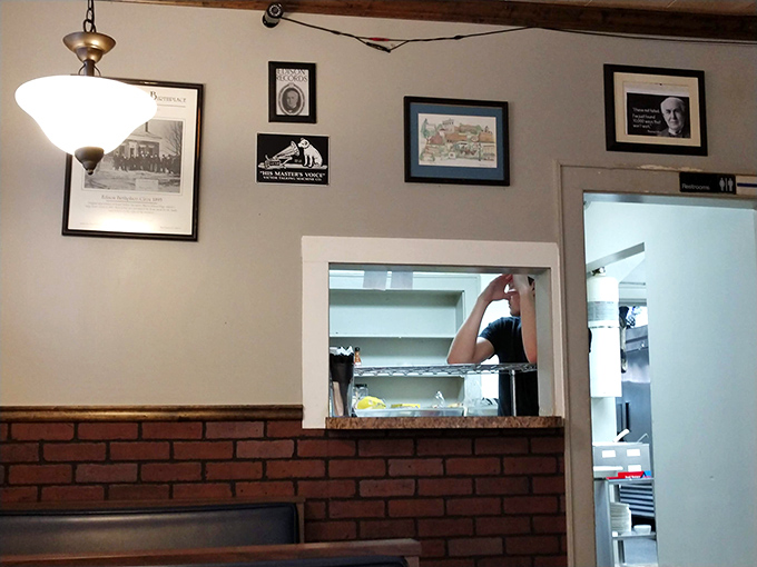 The pass-through window to the kitchen isn't just functional—it's theater, offering glimpses of culinary magic happening just beyond the dining room.