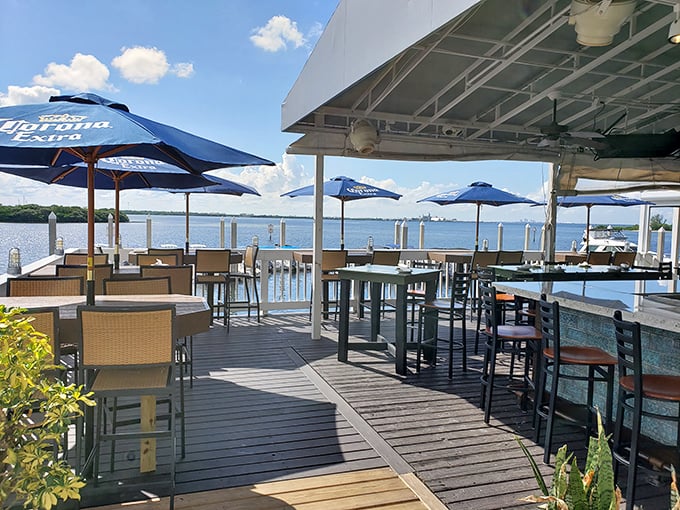 Waterfront dining that makes you wonder why you ever eat indoors. Those blue umbrellas aren't just for shade—they're framing devices for your Instagram story.