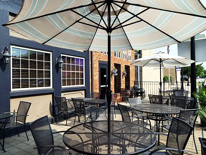 The patio where summer evenings stretch into memory-making territory. Those umbrellas aren't just blocking sun—they're creating personal dining oases.