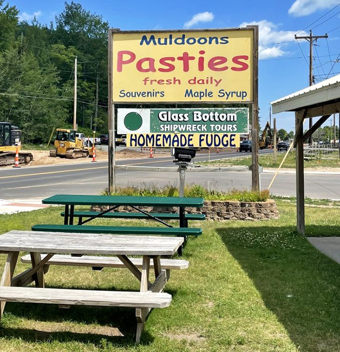 Picnic tables await beneath the famous Muldoons sign – because sometimes pasties taste even better in the fresh Michigan air with a view of passing traffic.