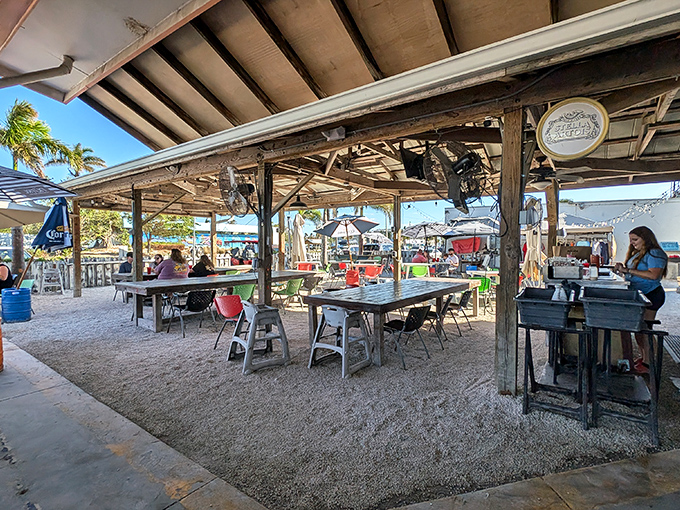 Rustic wooden beams frame the outdoor dining space where sandy feet are welcome and vacation memories are made between bites.