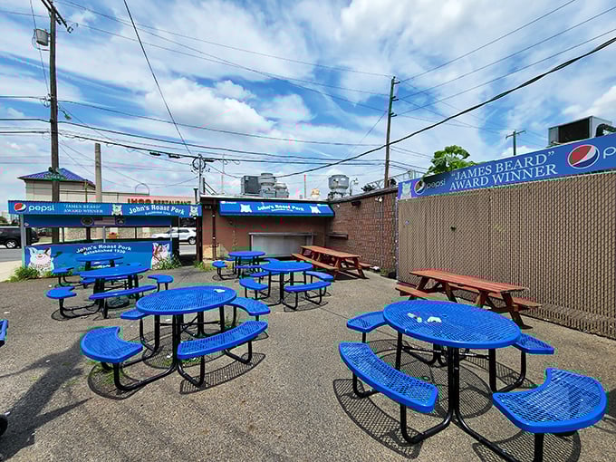 Outdoor seating that's as unpretentious as the food. Blue tables under the Philly sky—the perfect stage for sandwich appreciation.