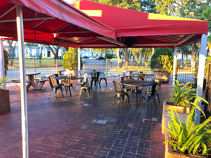 The outdoor patio—where Florida sunshine meets New England flavors. Those red awnings aren't just for shade; they're setting the stage for seafood theater.
