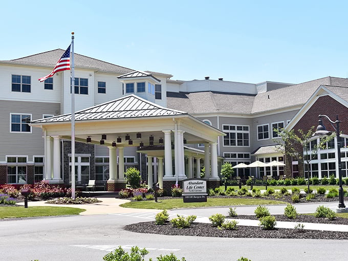 The Passavant Community's welcoming entrance combines classic colonial architecture with meticulous landscaping—retirement living that doesn't scream "retirement."