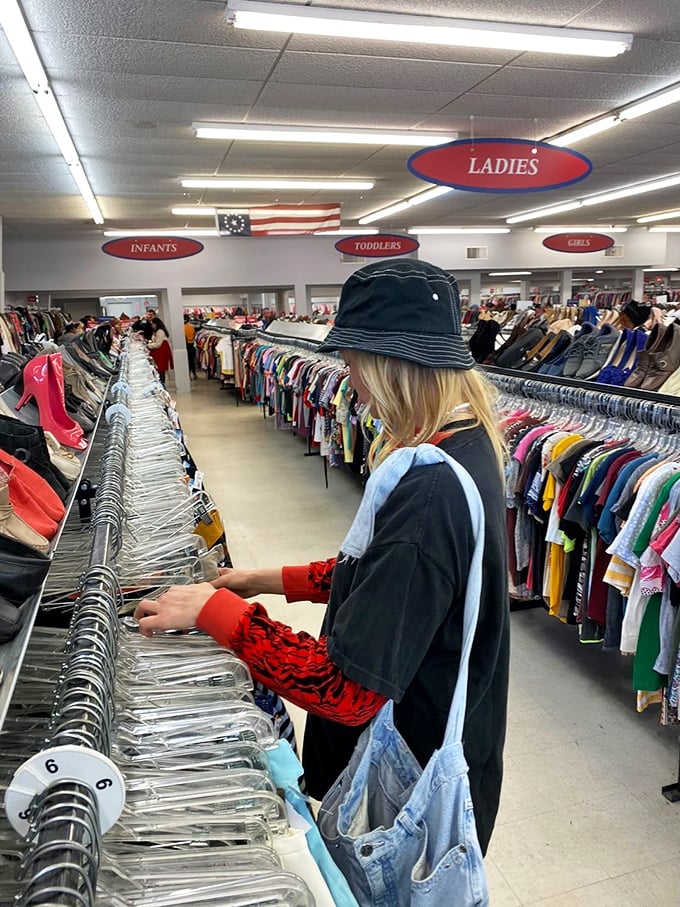 The thrift store shopper's stance—part detective, part fashion editor—methodically scanning racks for that perfect hidden gem.