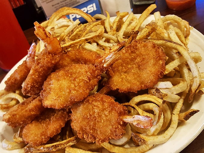 Crispy golden shrimp nestled among curly fries – proof that sometimes the best seafood comes from the most unexpected places.