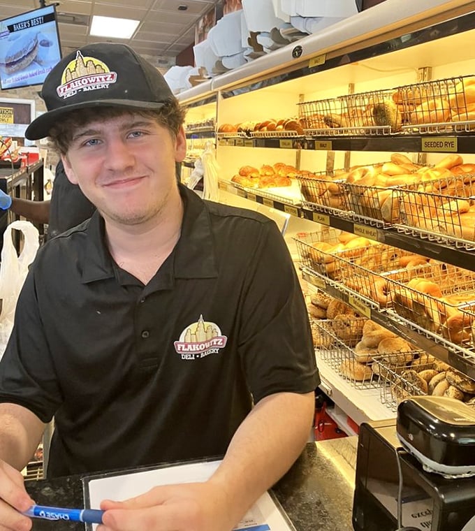 Behind every great deli is a team that knows their bagels—this staff member's smile suggests he's in on all the delicious secrets.