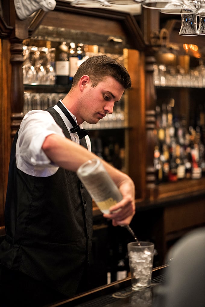 Craftsmanship in motion. The bartender prepares a perfectly balanced cocktail with the focus and precision that defines Aberdeen Barn's approach to hospitality.