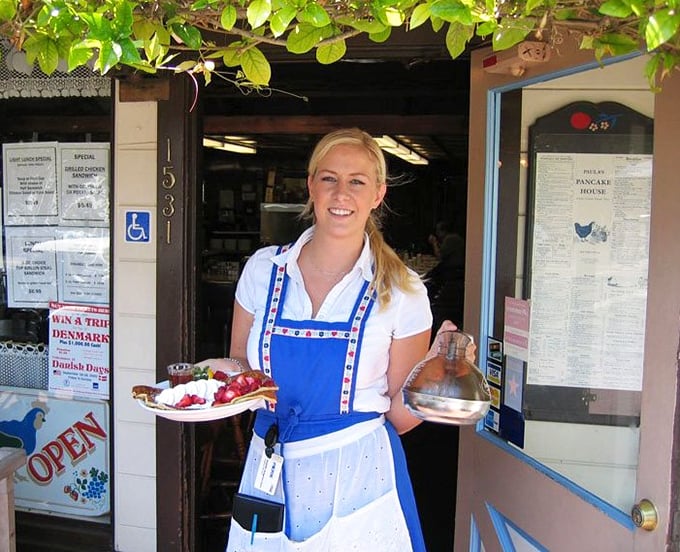 The front counter where breakfast magic begins. Those traditional Danish-inspired aprons aren't just for show—they're badges of pancake honor.