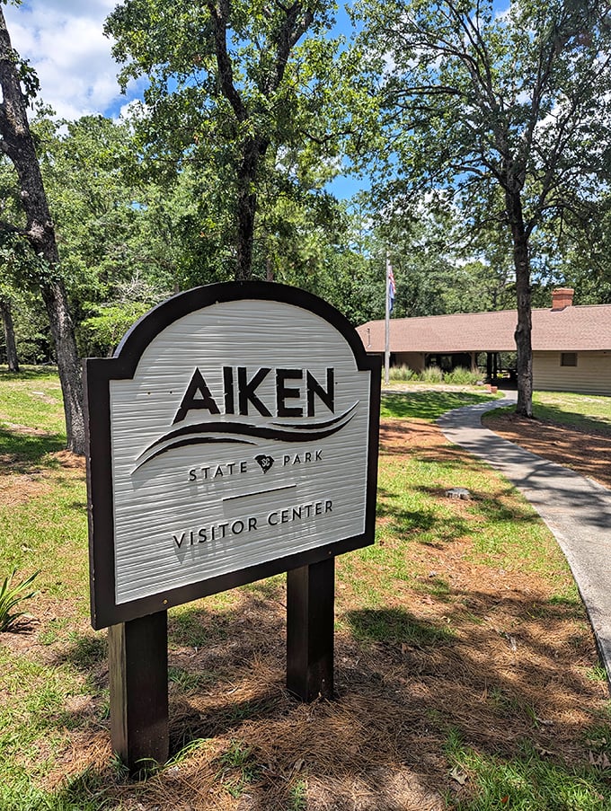 The Visitor Center sign doesn't just point the way—it's your first hello from a place that specializes in making you feel welcome in the wild.