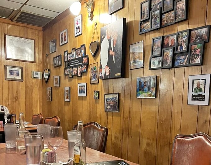 The wood-paneled wall gallery isn't interior decoration—it's a community scrapbook where every photo tells a Pensacola story.