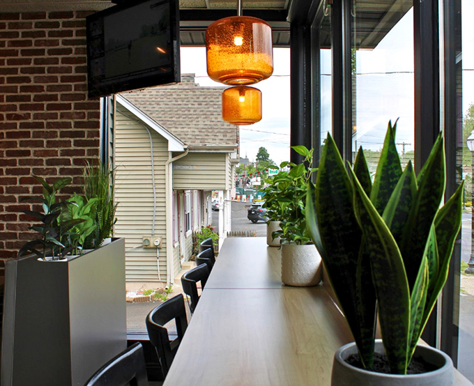 Window seats and plants create an unexpected oasis of calm, perfect for contemplating the deeper meaning of your next sandwich choice.