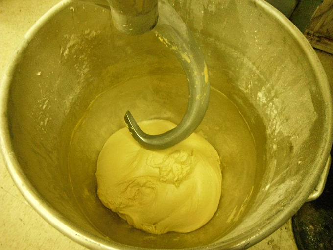 The industrial mixer—the unsung hero of the bakery world—kneading dough with the mechanical persistence that human arms could never match.