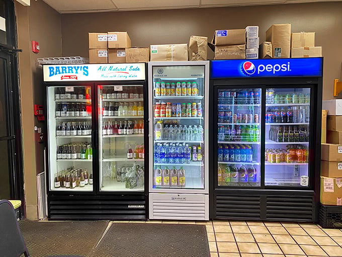 The beverage coolers—a colorful array of liquid refreshment options standing ready to combat the salt-induced thirst that follows cheesesteak bliss.