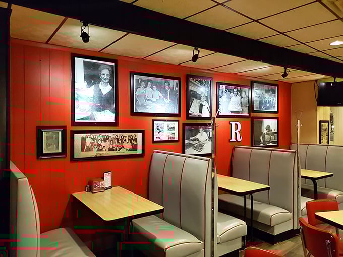 Red booths lined with history—where every black and white photo tells a story of the family legacy behind each perfect pizza cut.
