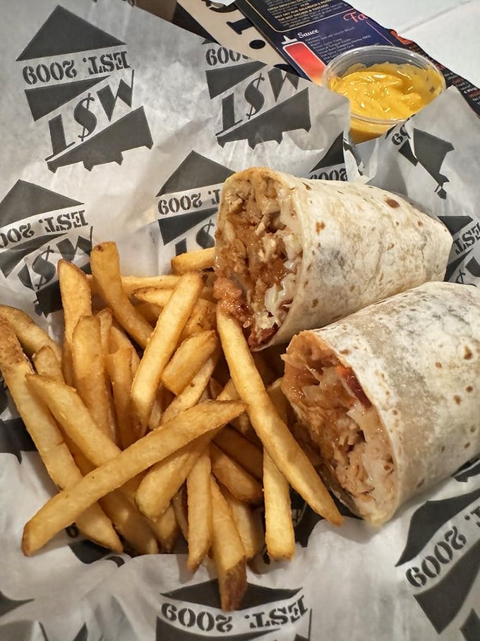 The perfect handheld meal: a burrito flanked by golden fries and a side of liquid sunshine. Portable perfection for the discerning diner.
