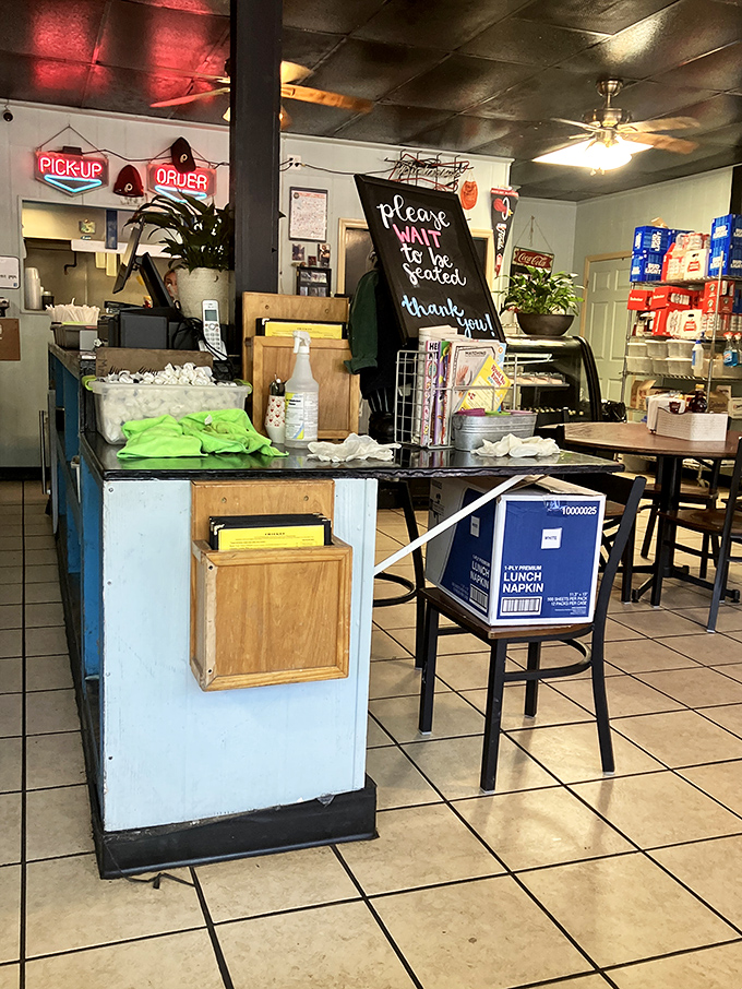 The counter area with its "Please Wait to be Seated" sign—the gateway to breakfast paradise and keeper of the napkin kingdom.