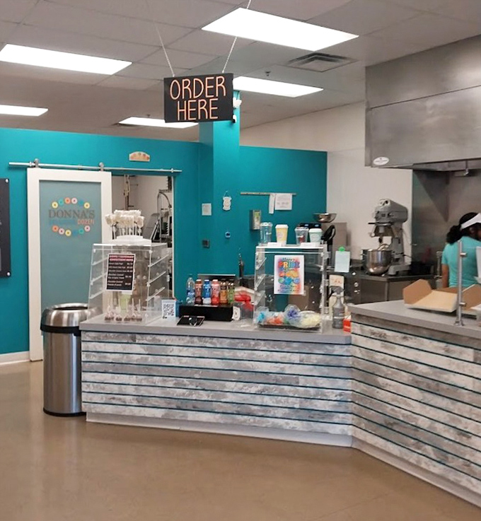 At the ordering counter, dreams come true under a neon "ORDER HERE" sign – three words that promise imminent donut satisfaction.