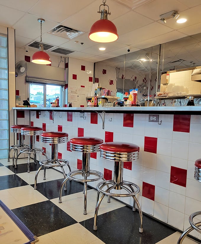 Those chrome-trimmed stools aren't just seating—they're front-row tickets to the greatest show on earth: short-order cooks performing breakfast ballet.