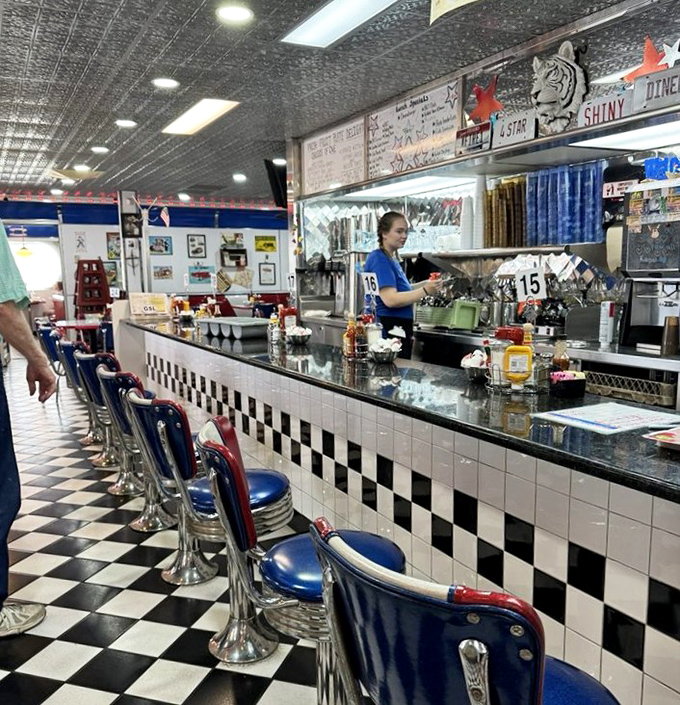 The counter seats—front-row tickets to the greatest show in town, where short-order cooks perform culinary ballet with spatulas as their batons.