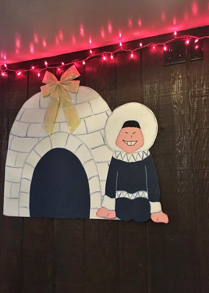 The charming igloo mascot watches over diners like a friendly guardian of good food—complete with festive string lights for extra warmth.