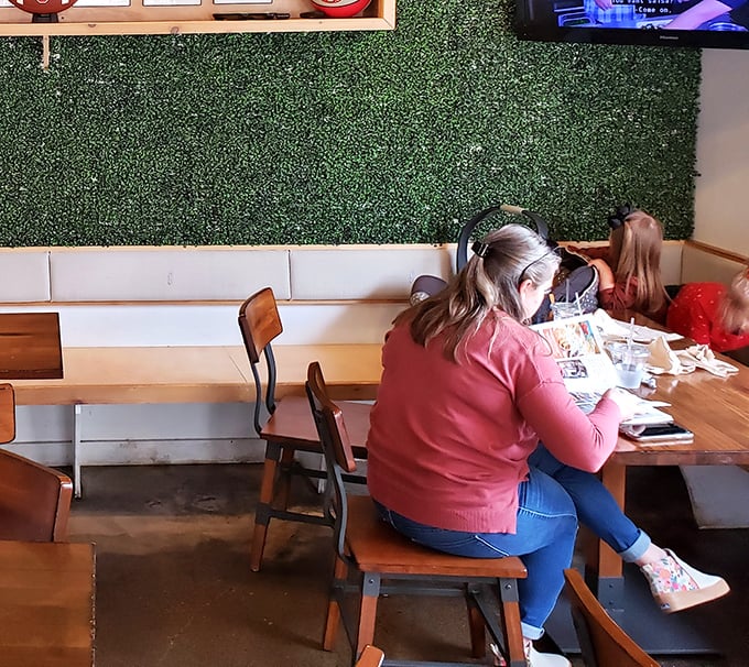 Diners settle in against the signature green wall, focused on the serious business of enjoying some of Columbus's most talked-about chicken.