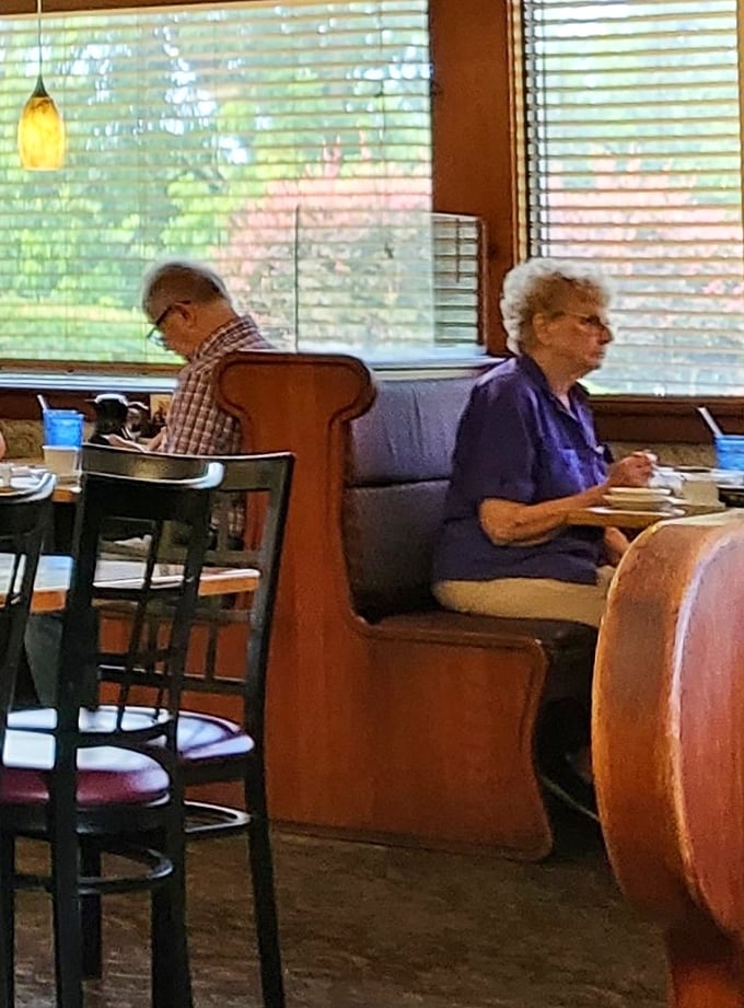 Regular customers in their natural habitat—the corner booth where they've likely been solving the world's problems over coffee for decades.