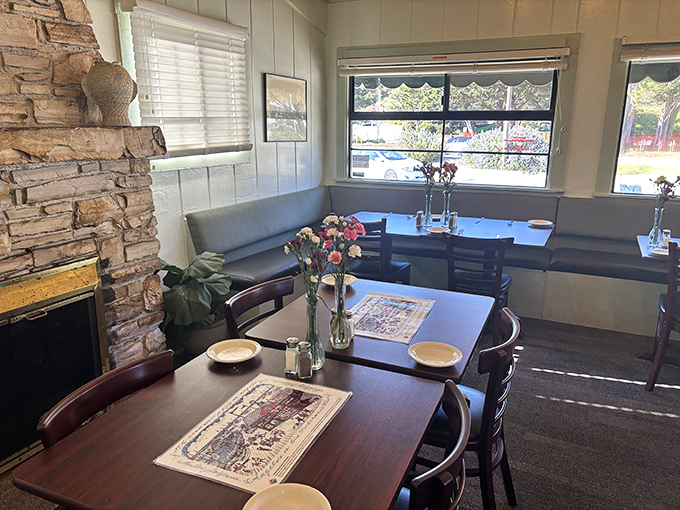 Stone fireplace meets seaside charm in this cozy dining nook. Those paper placemats have witnessed countless seafood epiphanies.