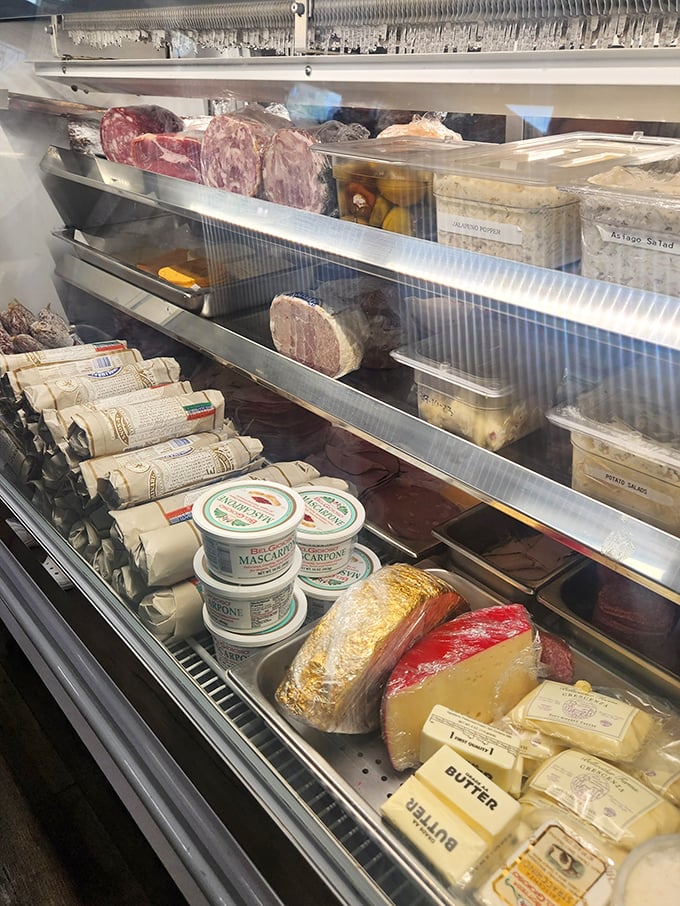 The deli case—where dreams are born and diets go to die. Each container holds the promise of flavors that chain supermarkets can only imitate.