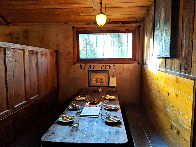 STAY HERE isn't just written on the wall—it's what your heart says when you enter this intimate dining nook with its wooden walls and perfectly set table.