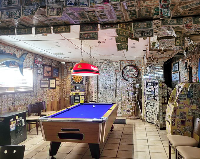 The pool table waits for challengers beneath a canopy of currency—games here aren't just games, they're desert traditions.